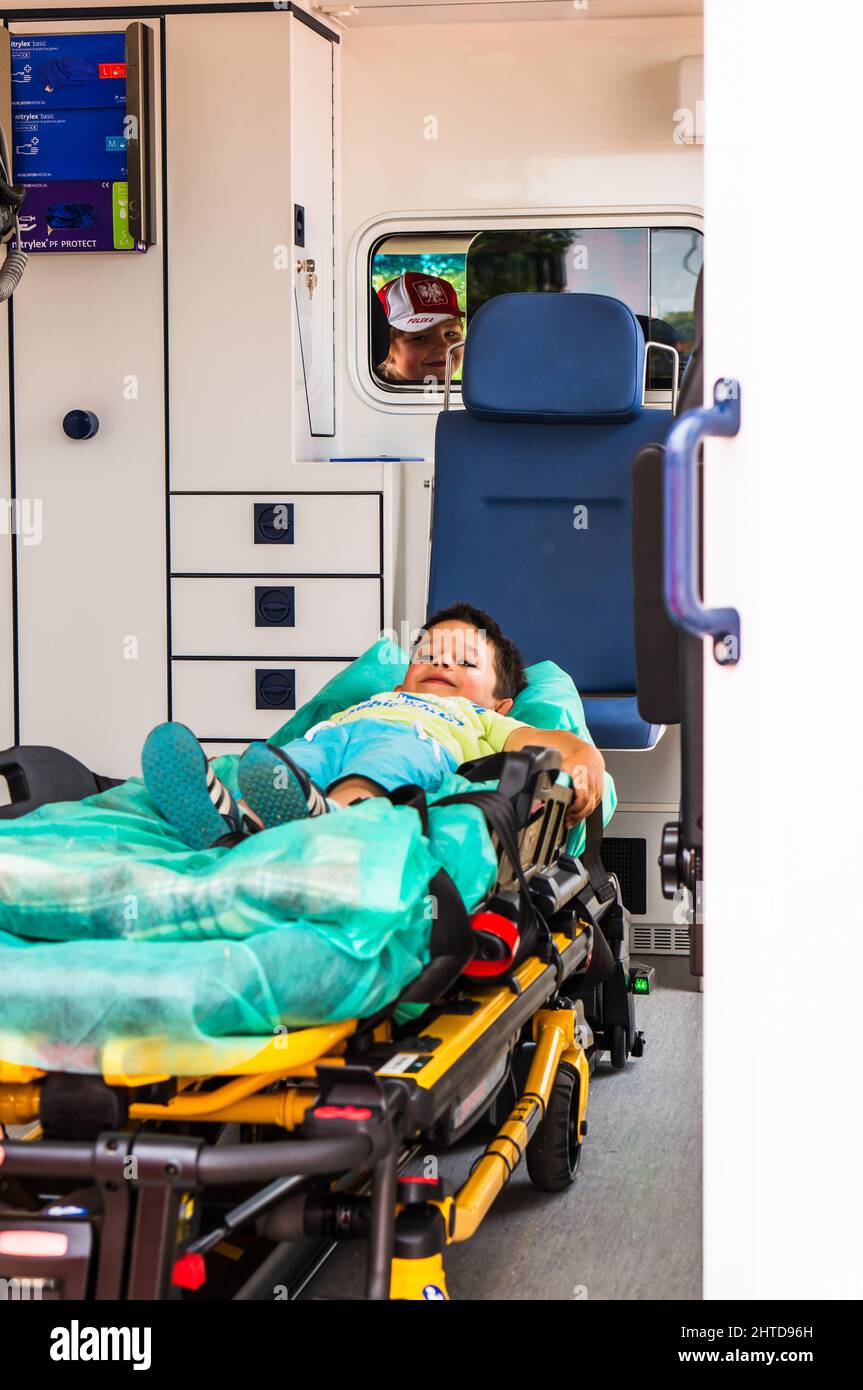 Young boy laying in a carrier of an ambulance during a fire department ...
