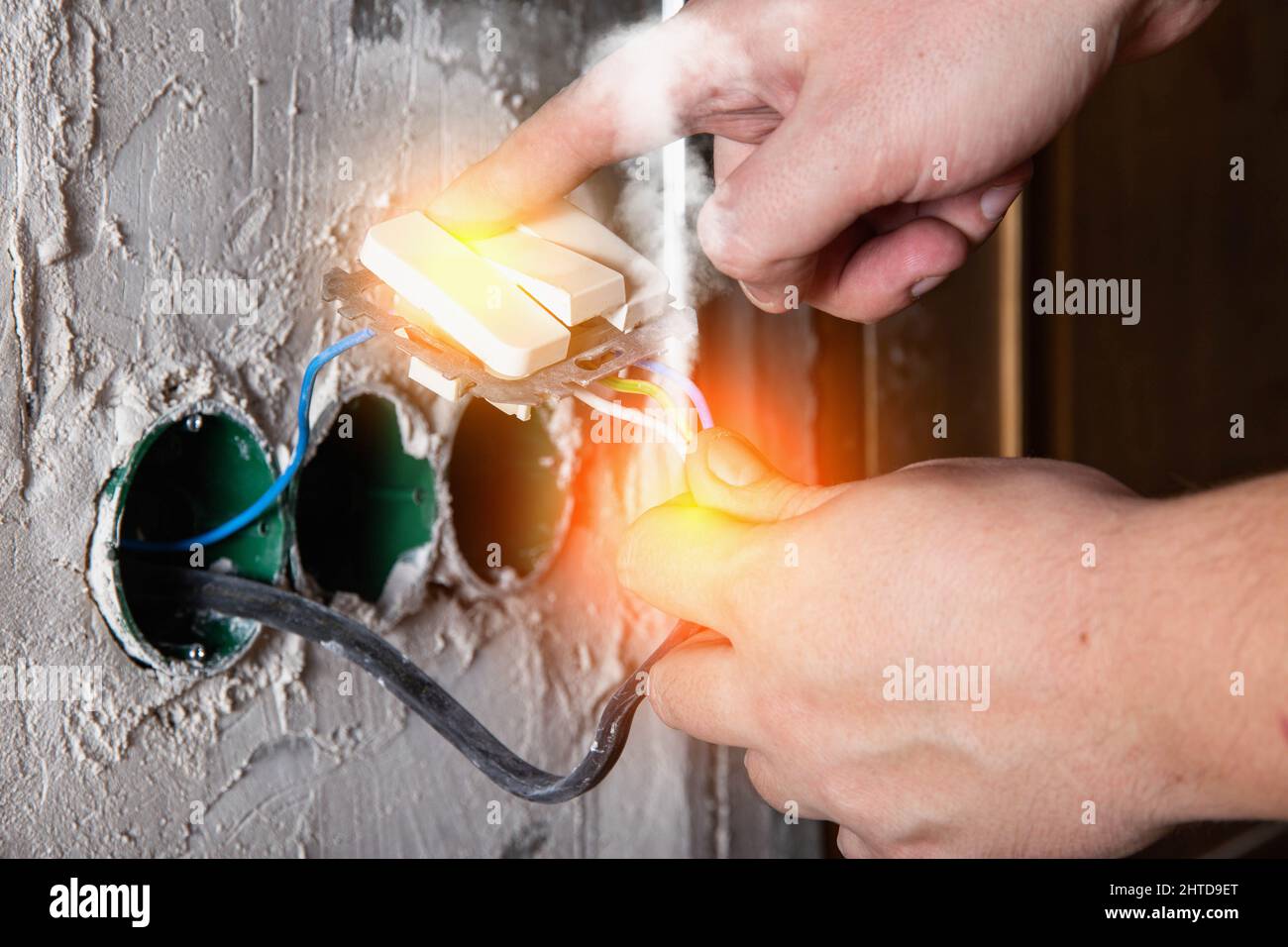 A man holds on to electrical wires and an electrical switch. Electric ...