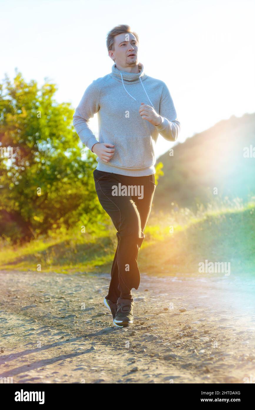 Running man jogging in rural nature at beautiful summer day. Sport ...