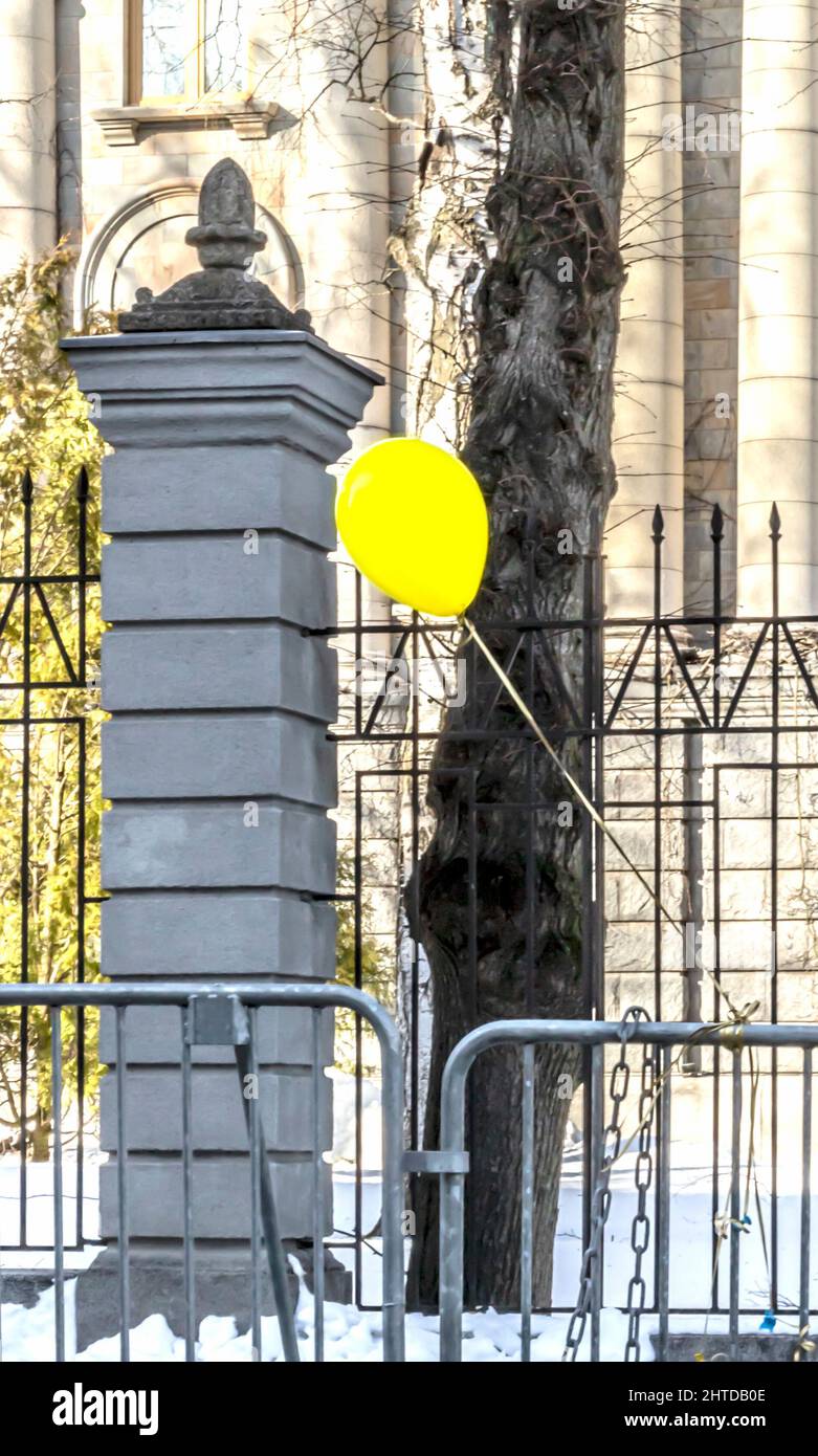A yellow balloon tied to a crowd control barrier outside the Russian ...
