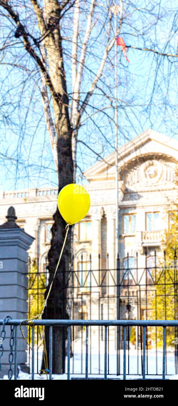 A yellow balloon tied to a crowd control barrier outside the Russian ...