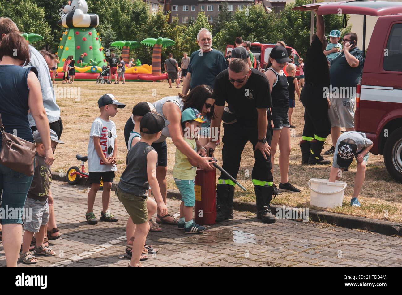 Child and a fireman shooting with water during a fire department event ...