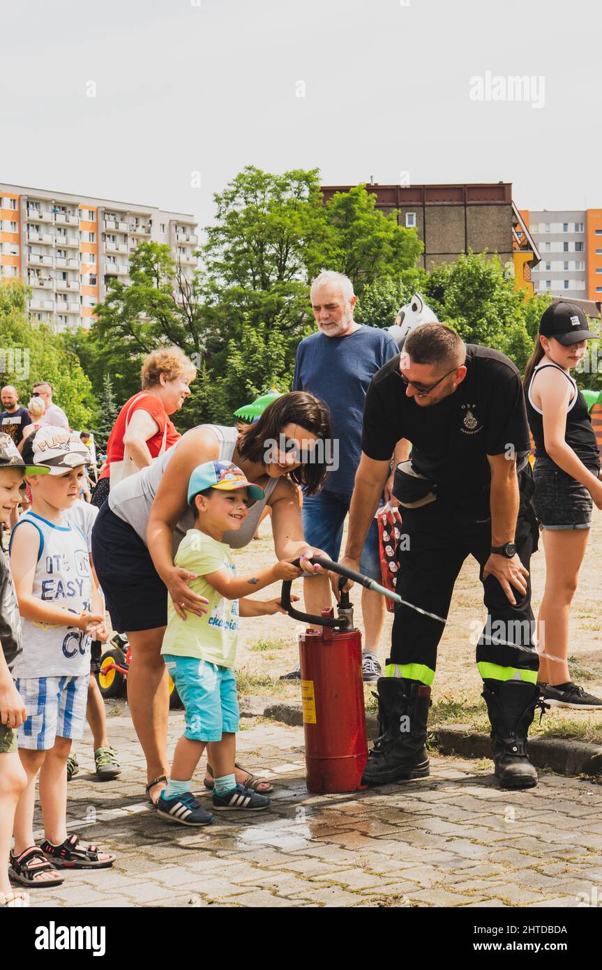 Child and a fireman shooting with water during a fire department event ...