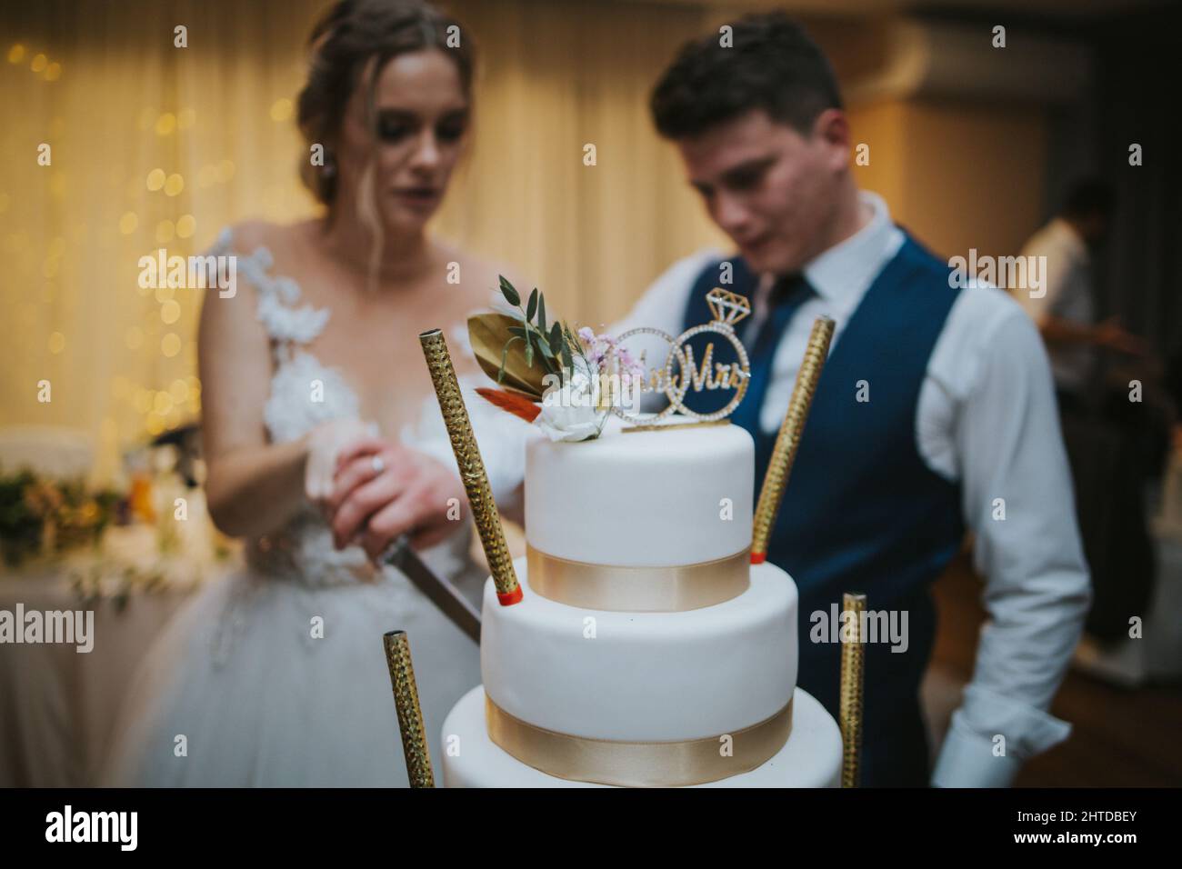 Beautiful couple cutting a wedding cake Stock Photo - Alamy