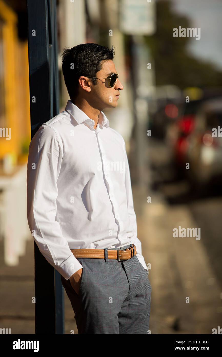 Vertical shot of the South Asian male standing and leaning on the light ...