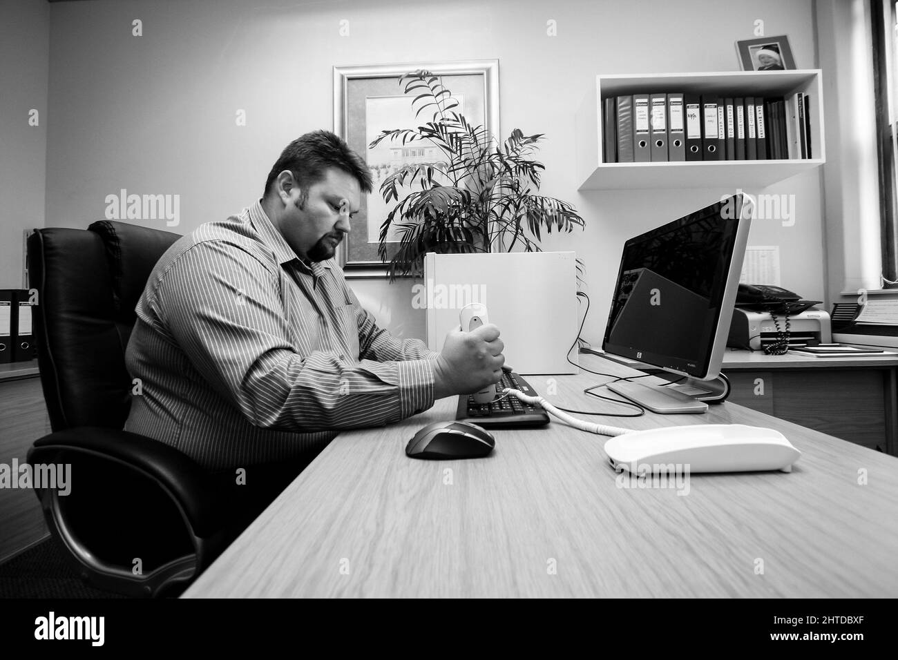 Grayscale shot of an IT maintenance professional man working on a ...