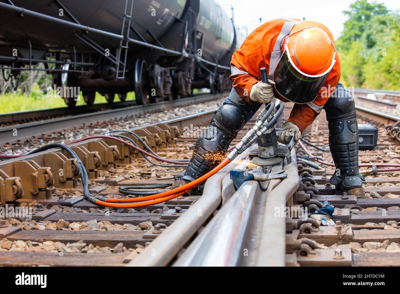 Worker in the process of a railroad track weld repair with a freight ...