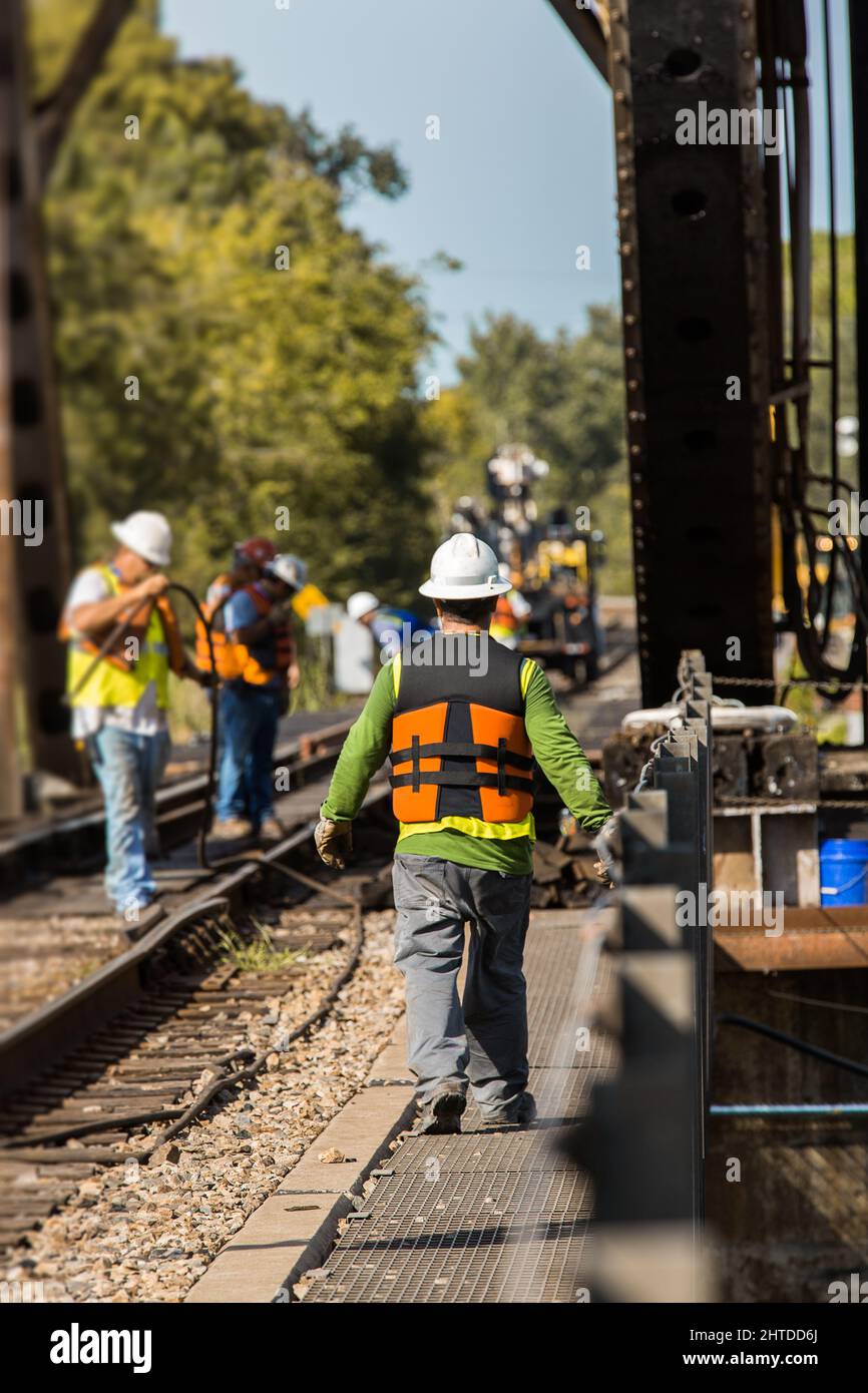 Workers in the process of railroad track construction - rail saw with ...