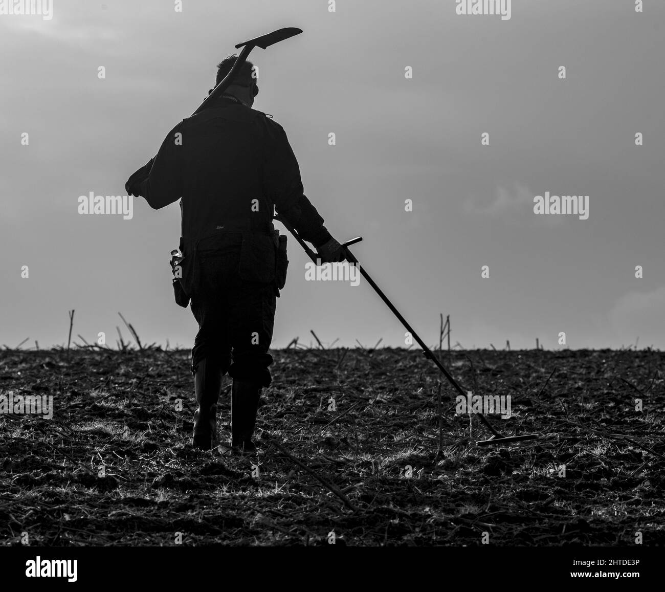 Metal detectorist with a spade over the shoulder Stock Photo - Alamy