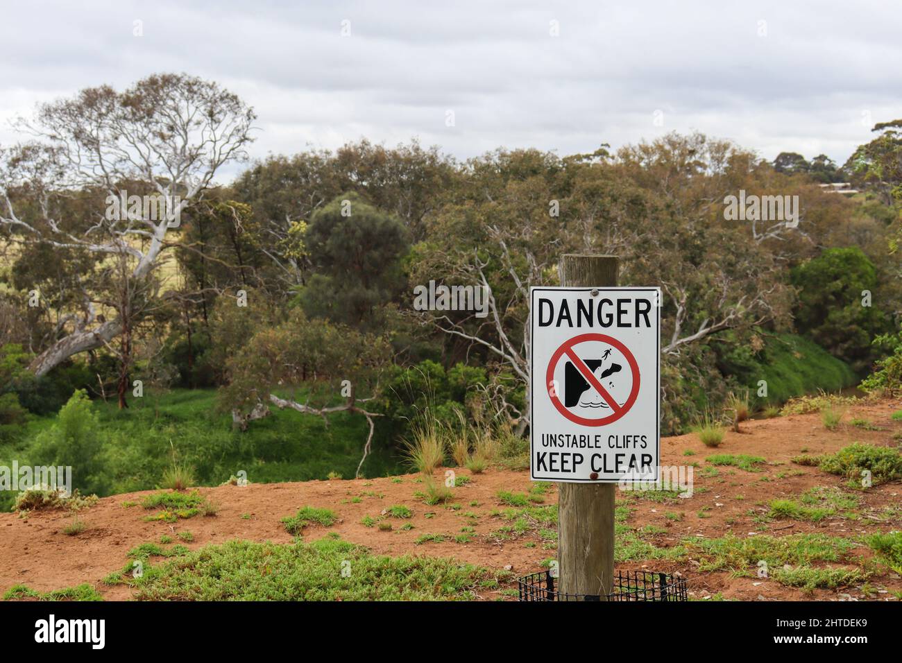 Danger sign in the forest with the trees and the cloudy sky in ...