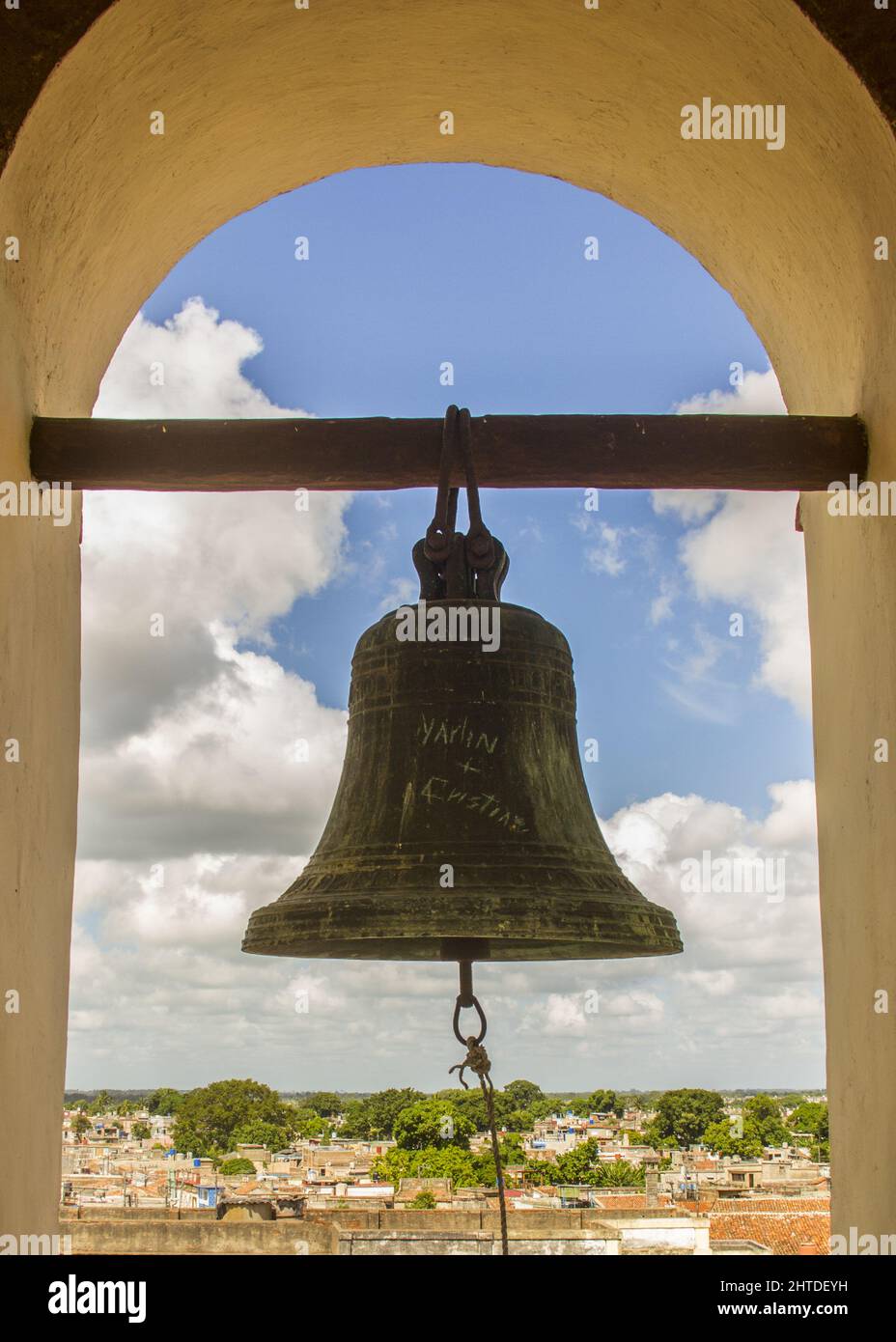 Closeup shot of a bell in the tower with a mesmerizing cityscape in the ...