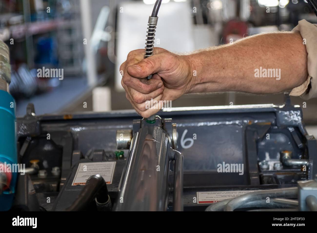 Hand greasing the front of a piece of a loader, taking care of ...