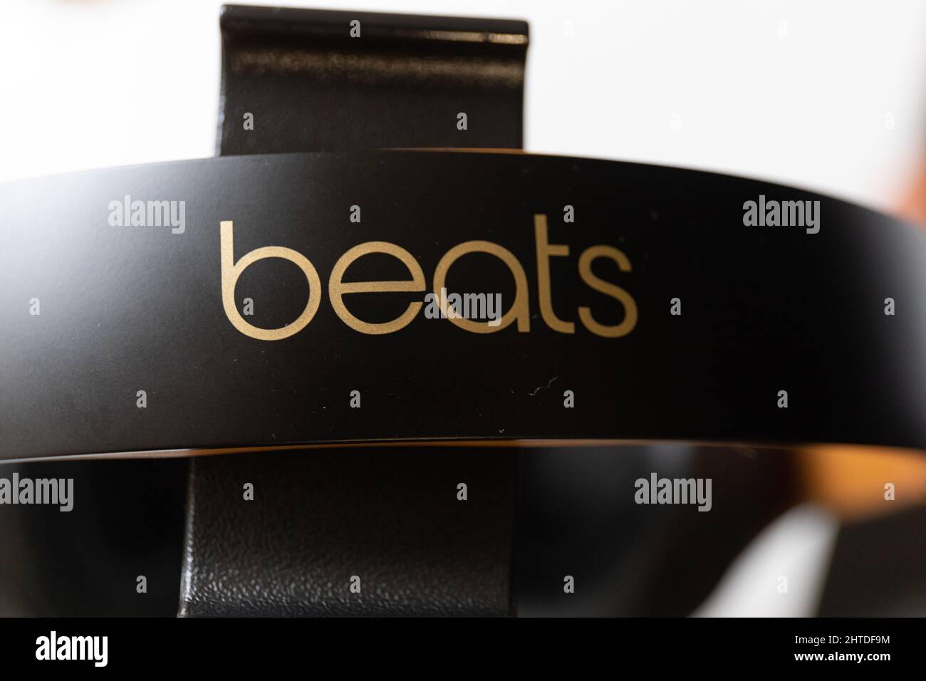 A close-up shot of the golden Beats logo on black headphones Stock ...