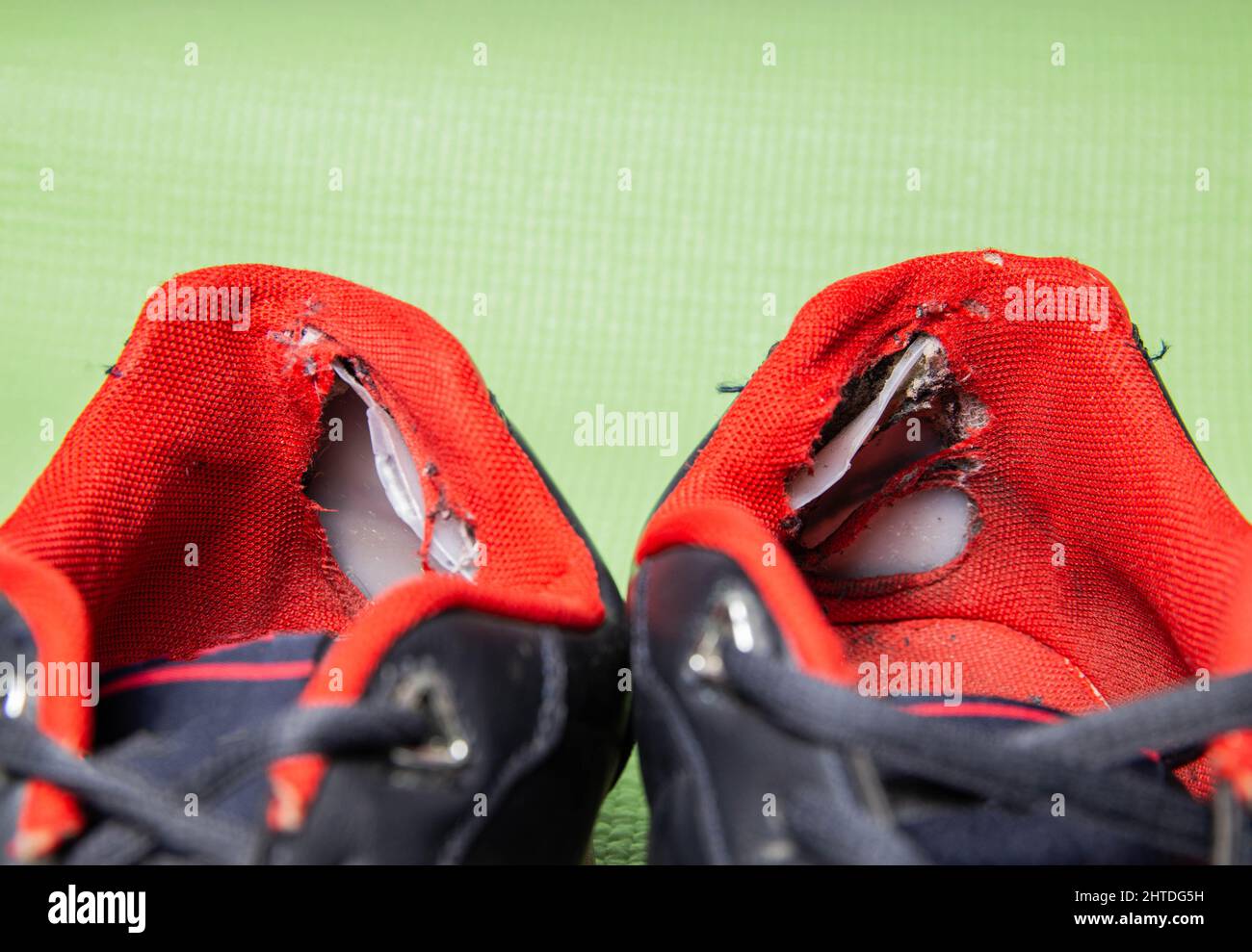 Old worn out ripped sneakers. Torn back in shoes, close-up. Shoe repair ...