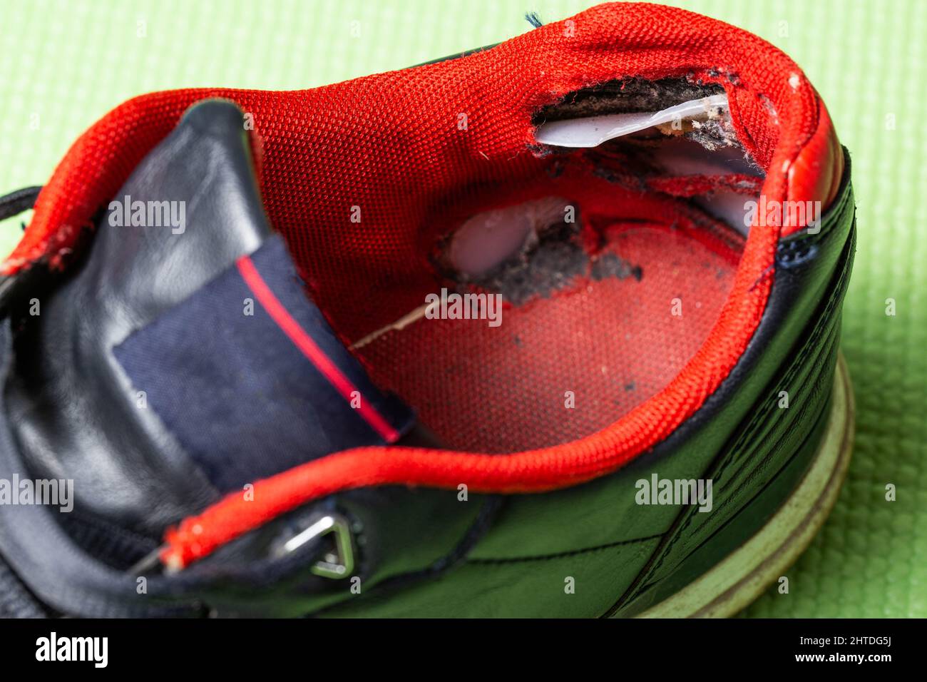 A ripped backdrop in sporty multicolored sneakers. Poor quality shoes ...