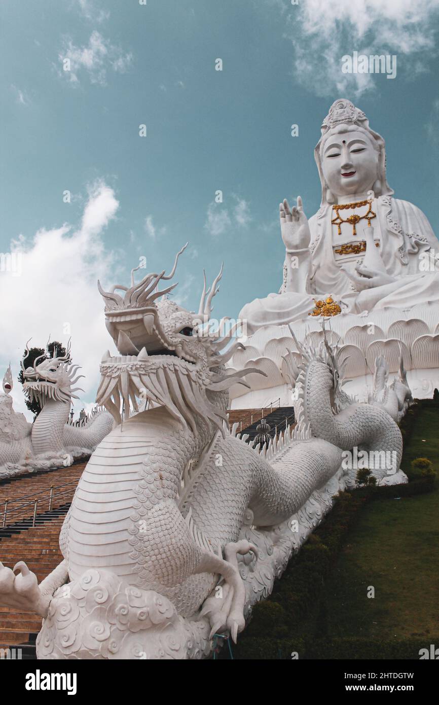 Vertical shot of the Asian statues over building under a cloudy sky ...