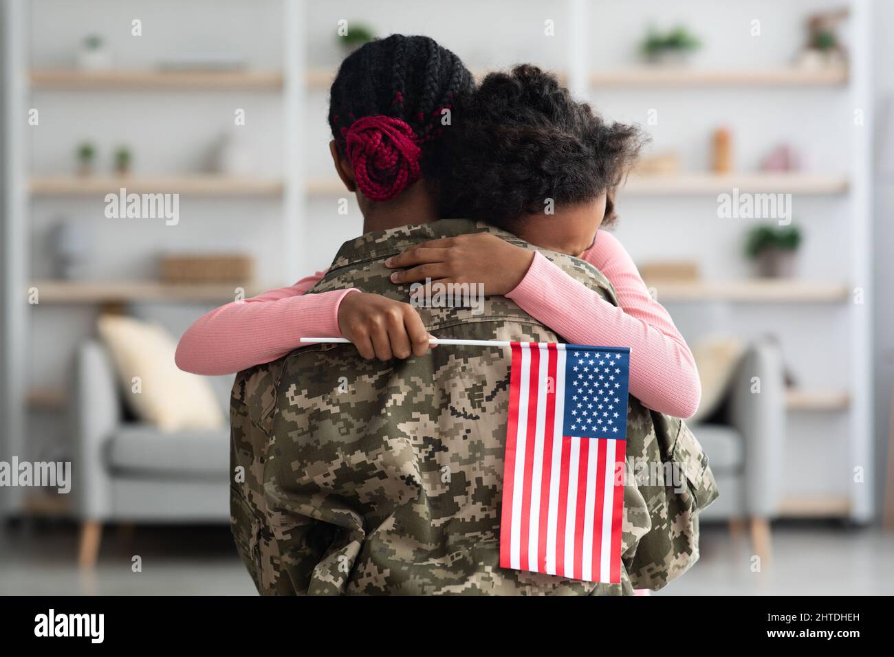 Emotional girl with flag of the US hugging her mom Stock Photo - Alamy