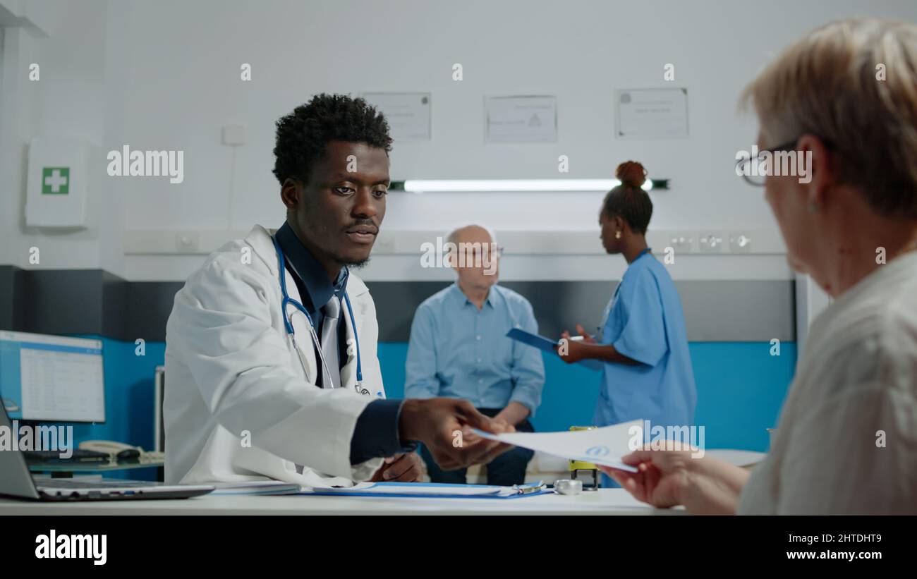 Doctor giving patient documents hi-res stock photography and images - Alamy