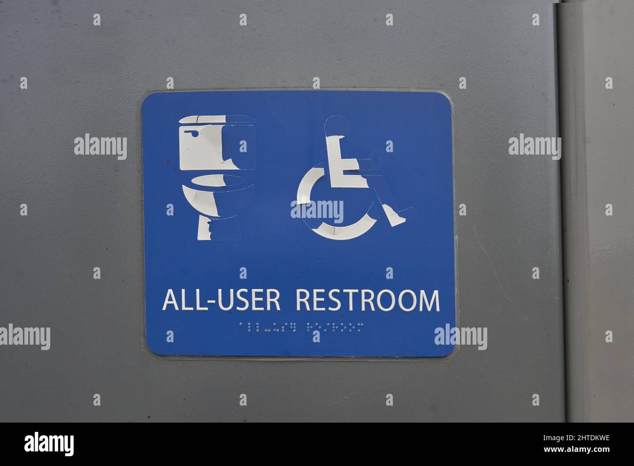 Blue and white all-user restroom sign on grey background showing half ...