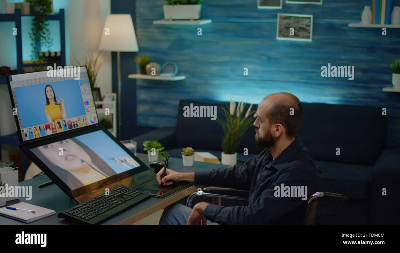 Disabled photographer retouching pictures at studio. Photography artist ...