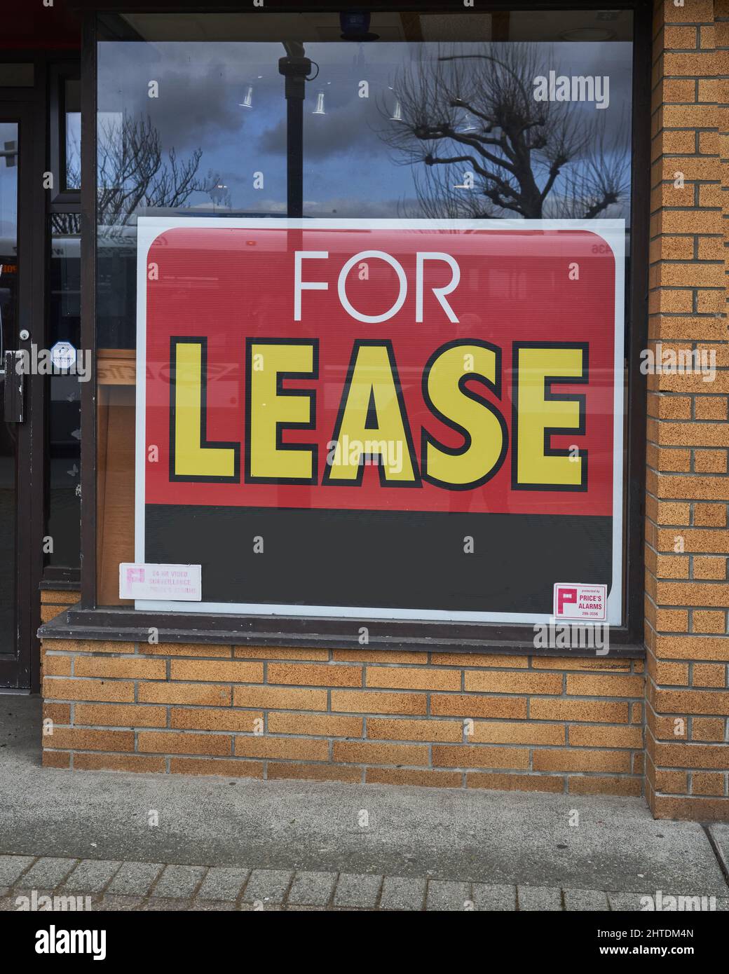 A large for lease sign in a store front window of a brick building ...