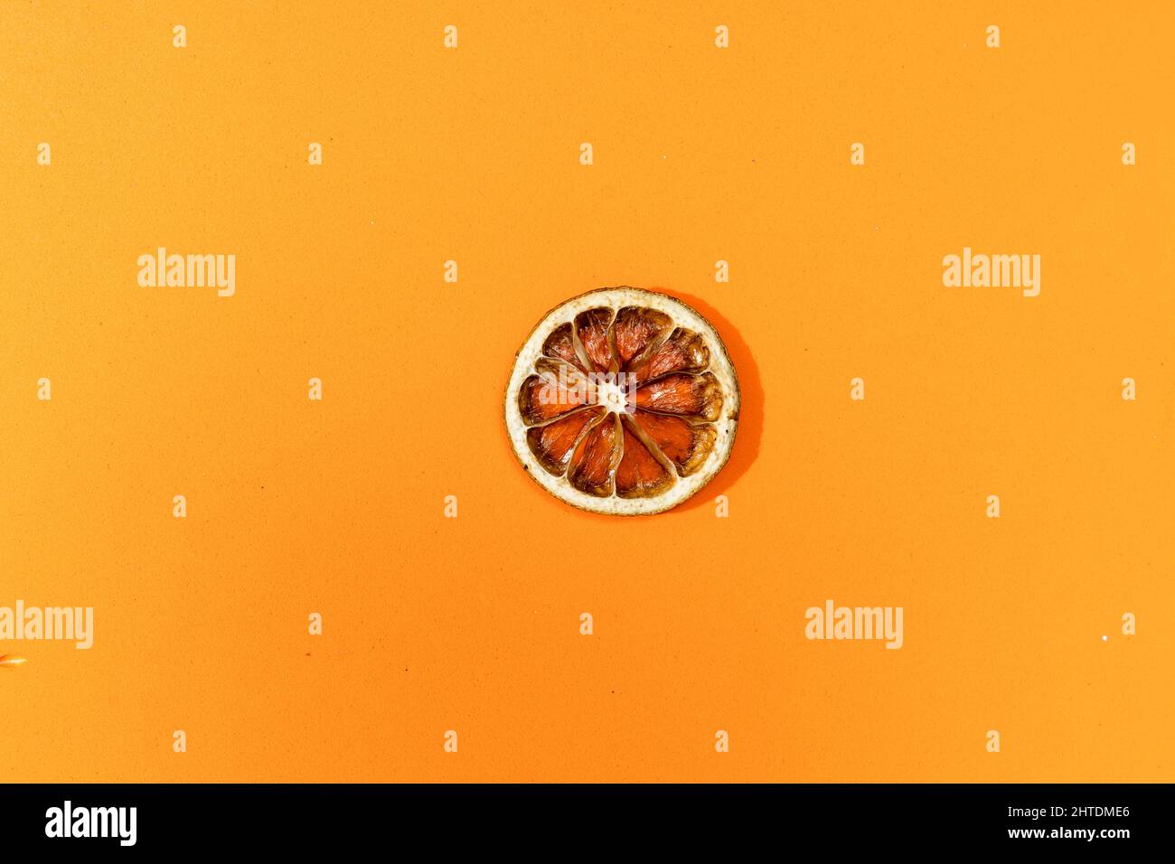 A Dissected orange slice on a orange surface Stock Photo - Alamy