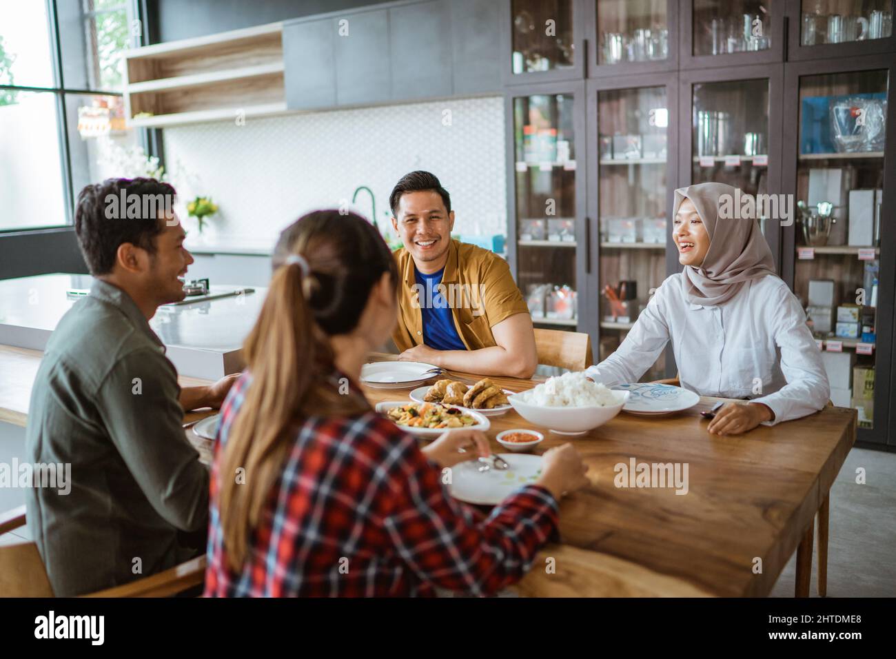 friends having fun eating lunch together at home with traditional food ...