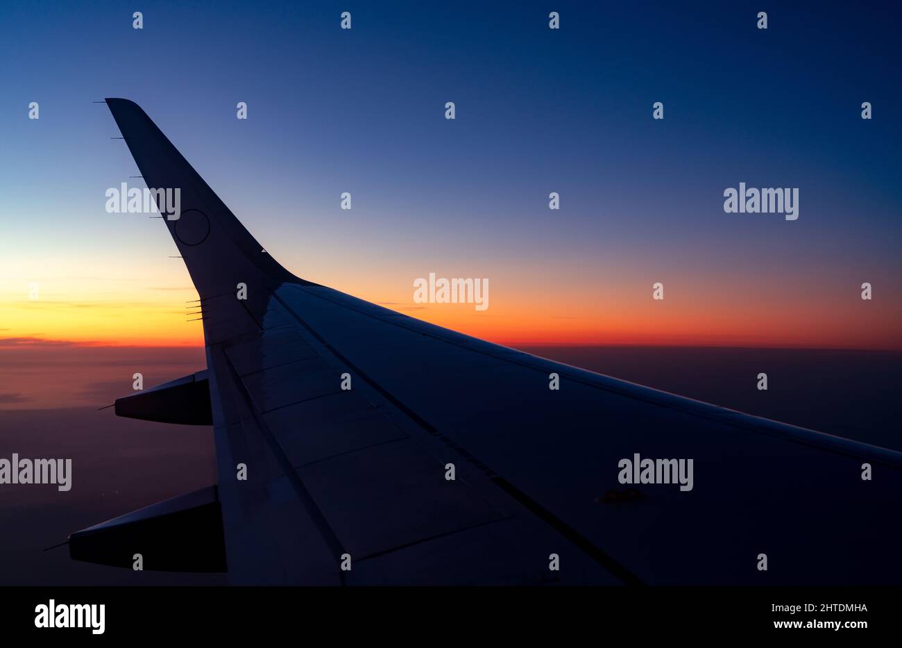 Wing of plane with sunrise skyline. Airplane flying in the sky. Scenic ...