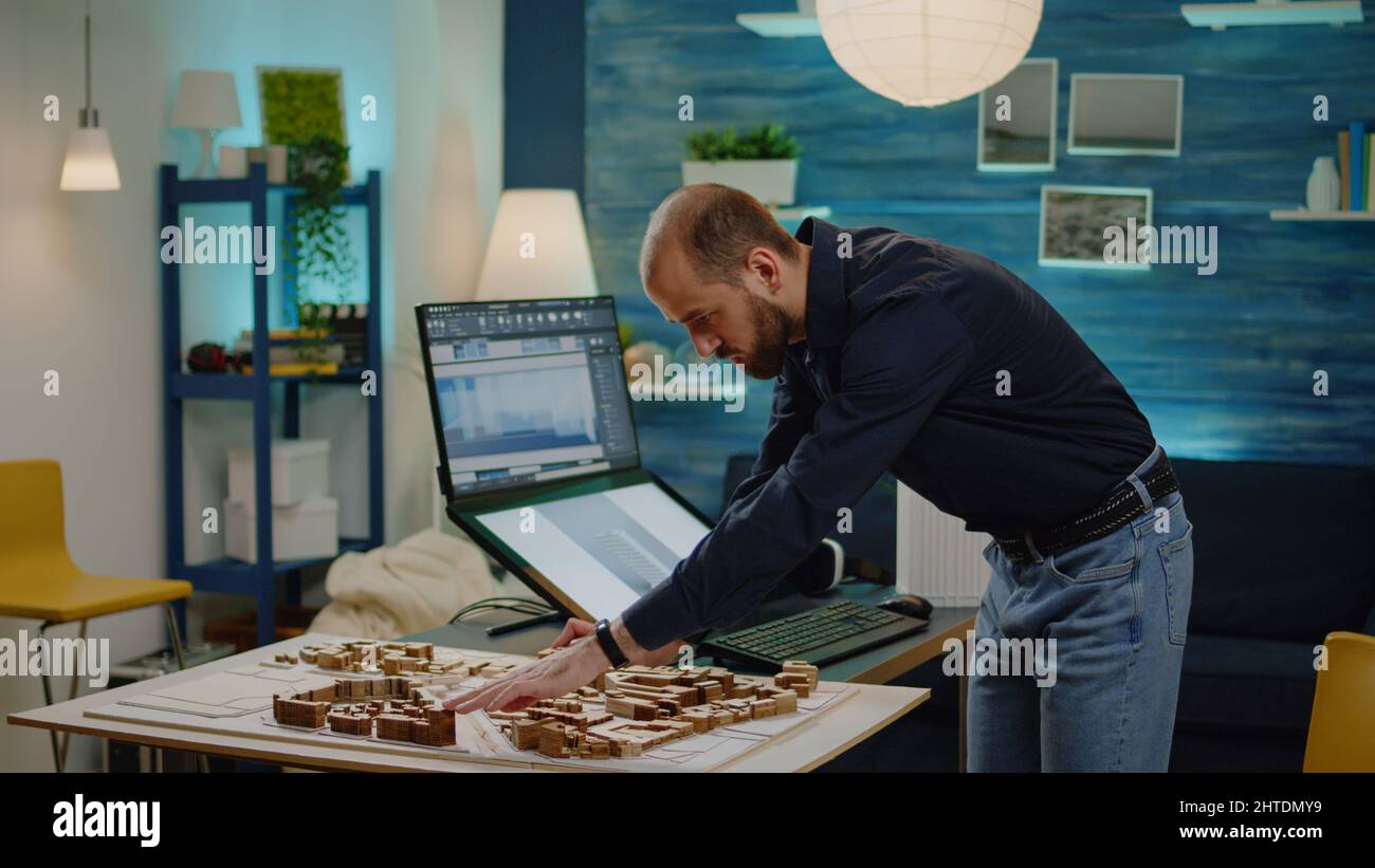 Man with architect job working on building model with touch screen ...