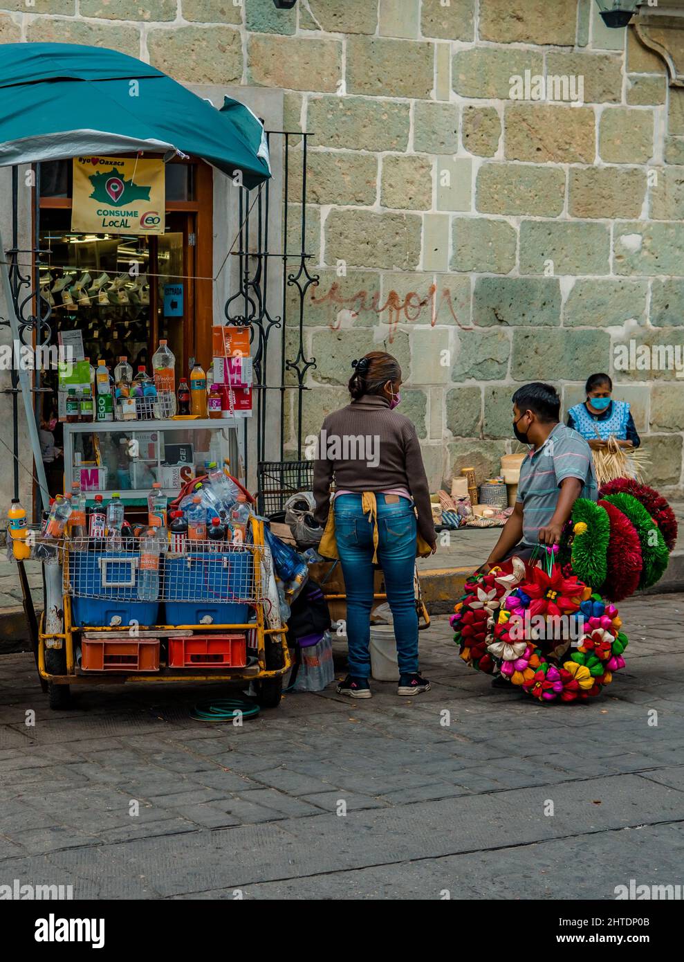 Vertical shot of street vendors sitting underneath the building wall in ...