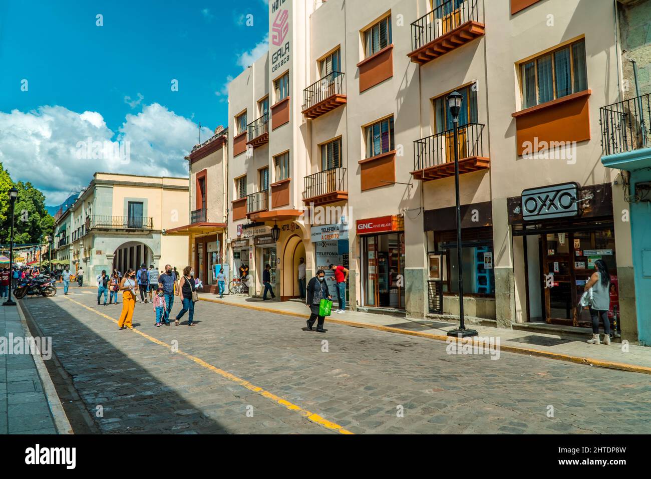 Photo of a street scene of locals walking with traditional architecture ...