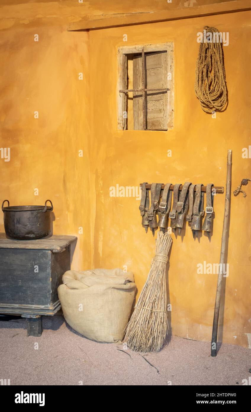 Vertical of vintage agricultural utensils in an old barn with yellow ...