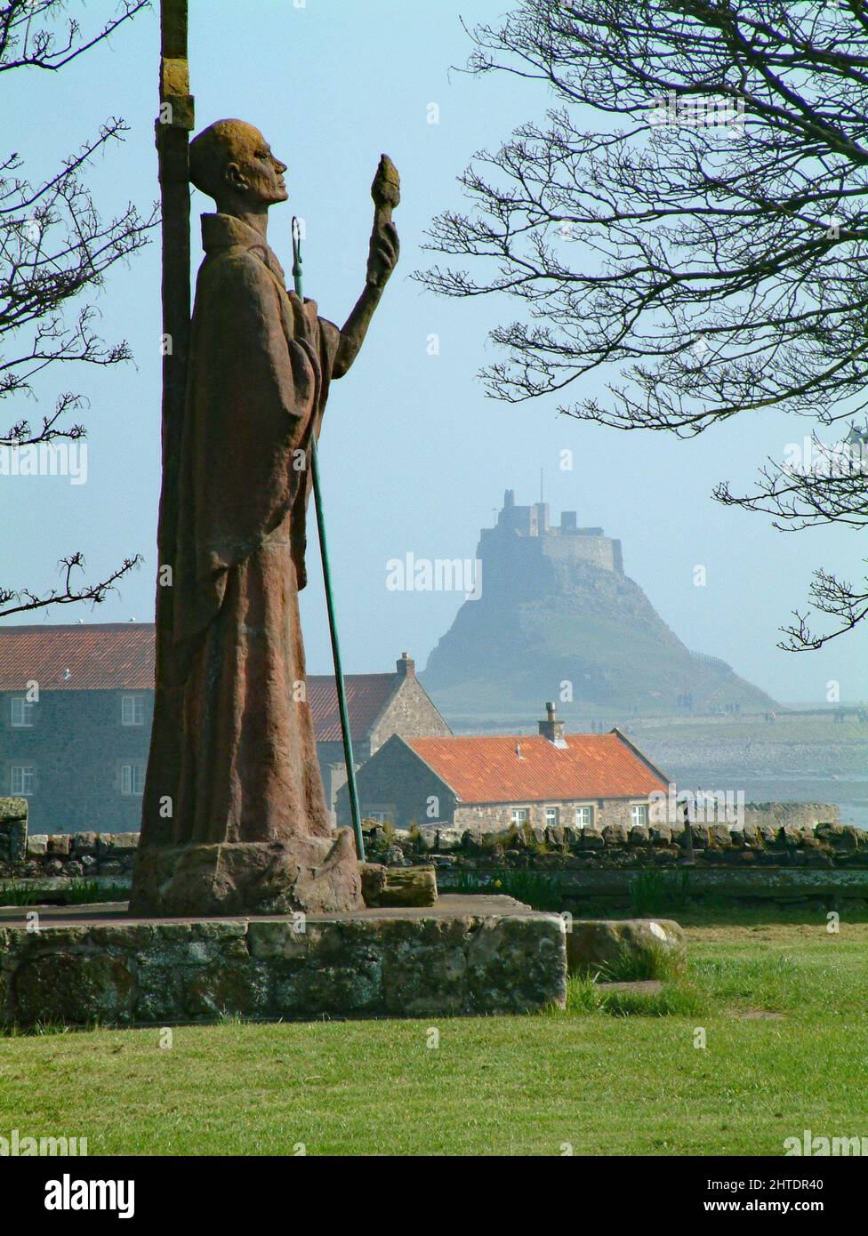 Vertical shot of the St Aidan statue and Lindisfarne Castle in ...