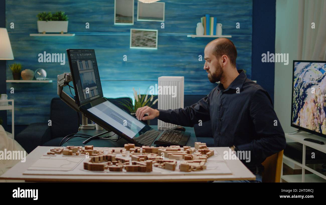 Architect analyzing building model on touch screen monitor for ...