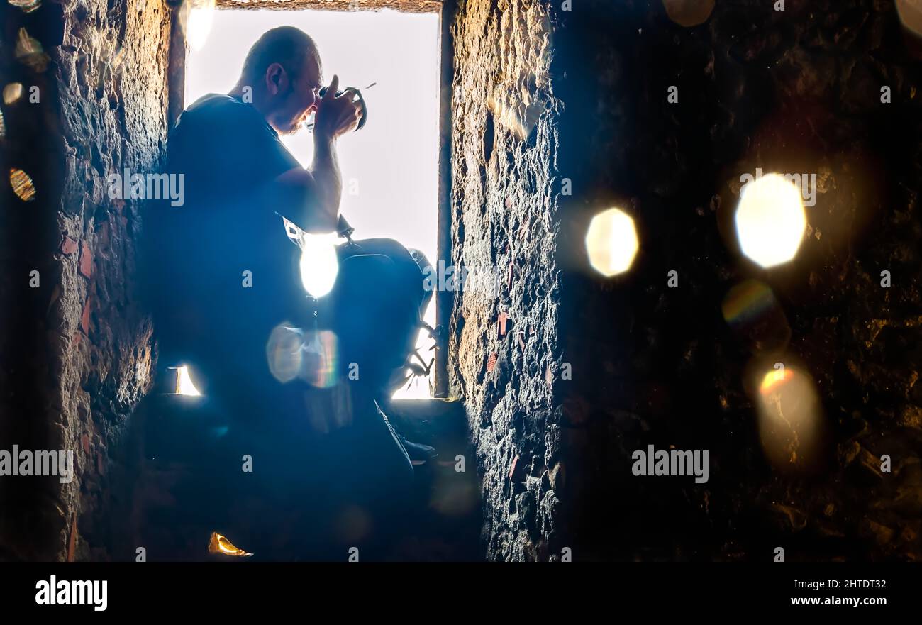 Photo of a man taking photographs with the light in front of the lens ...