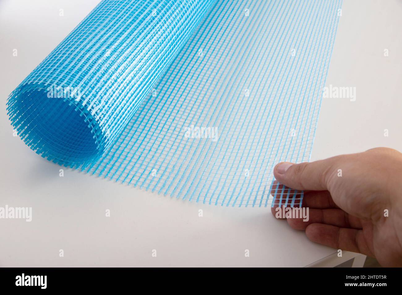 Blue reinforcing construction mesh for wall strengthening on white ...