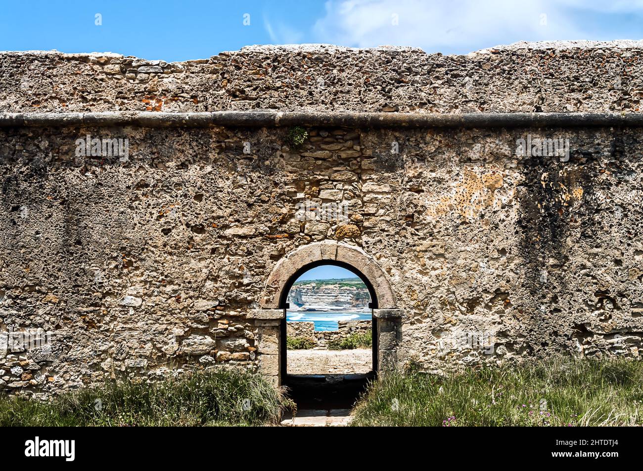 Photo of an ancient wall with a gate overlooking the sea Stock Photo ...