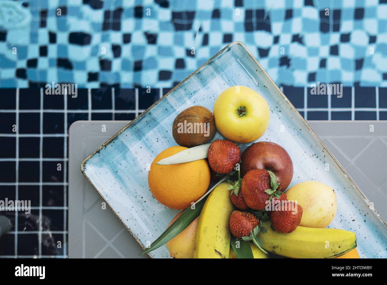 Plate of fruits on a background of tiles of a swimming pool Stock Photo ...