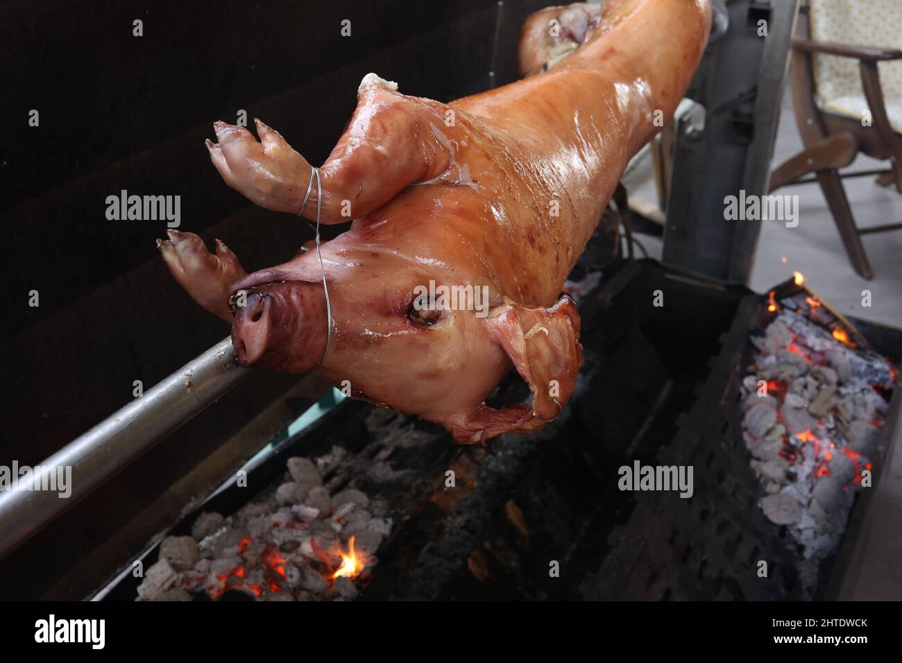 Pig is being grilled slowly on spit in traditional way Stock Photo - Alamy