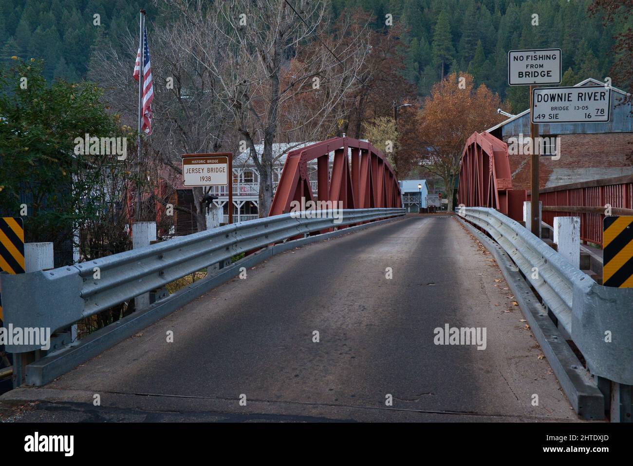 Bridge with road signs and the US flag in a small town of Downieville ...