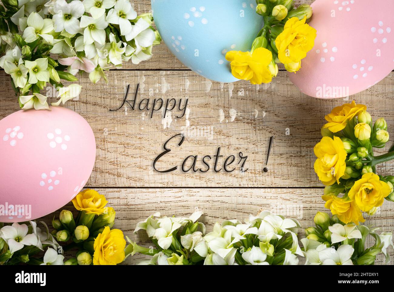 Easter border of decorated eggs and flowers on a rustic wooden ...
