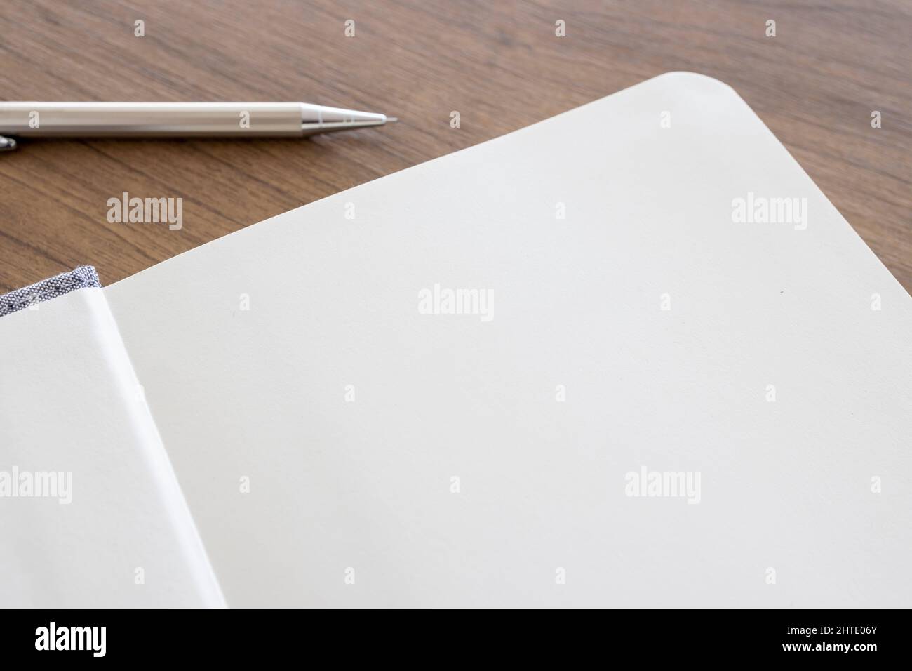 top view of blank open notebook page and pencil on wood table ...