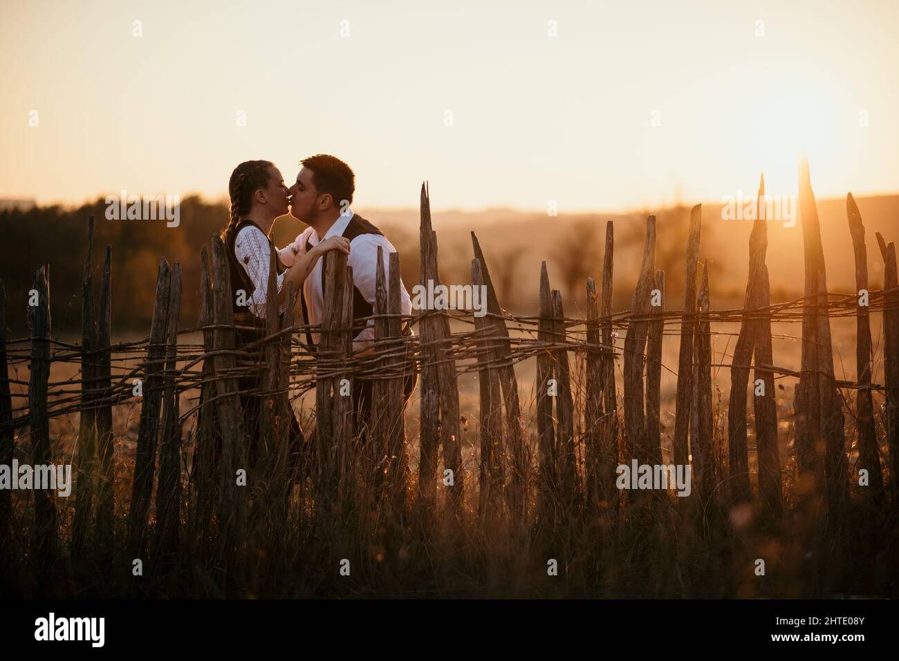 Beautiful shot of a Serbian couple in traditional costume kissing ...