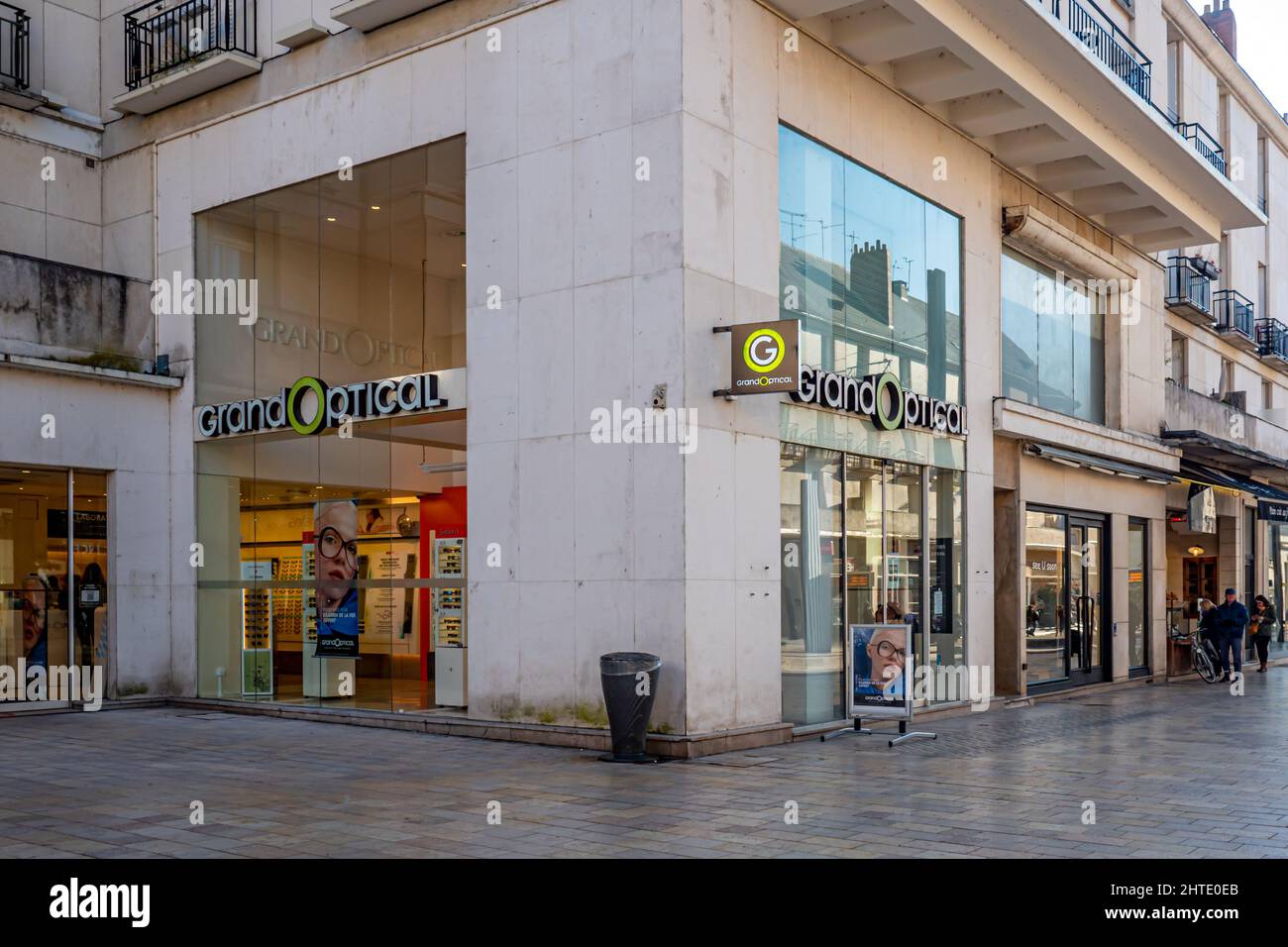 GRAND OPTICAL Optician store facade side view with logo and signage ...