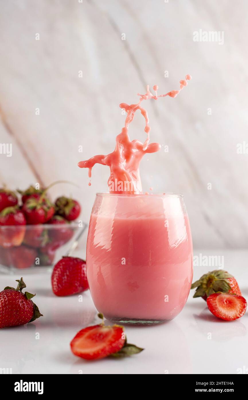 Strawberry milk shake with strawberries around on white background ...