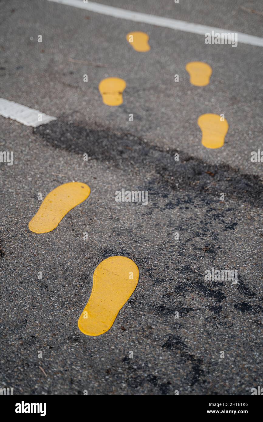 Vertical shot of a walkway line with yellow painted footsteps Stock ...