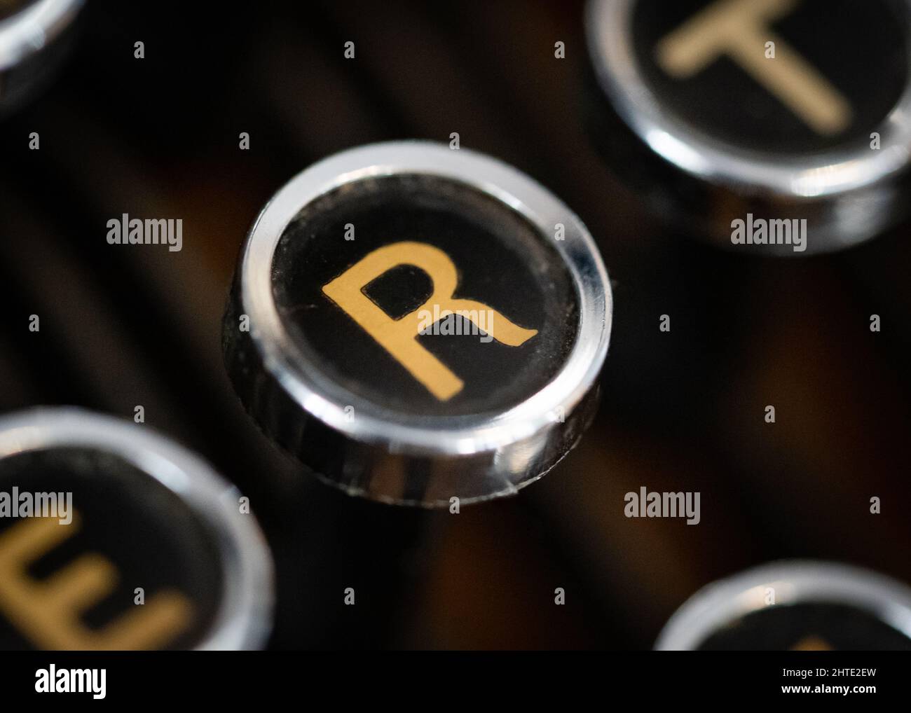 Retro vintage typewriter circular round key closeup with gold coloured ...