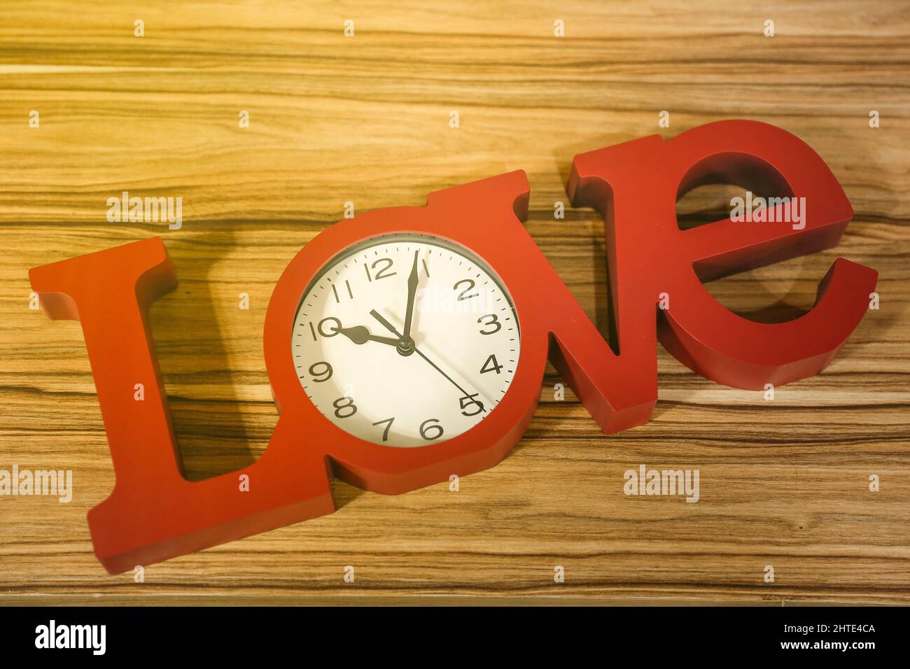 love wooden letters on clock in red color Stock Photo - Alamy