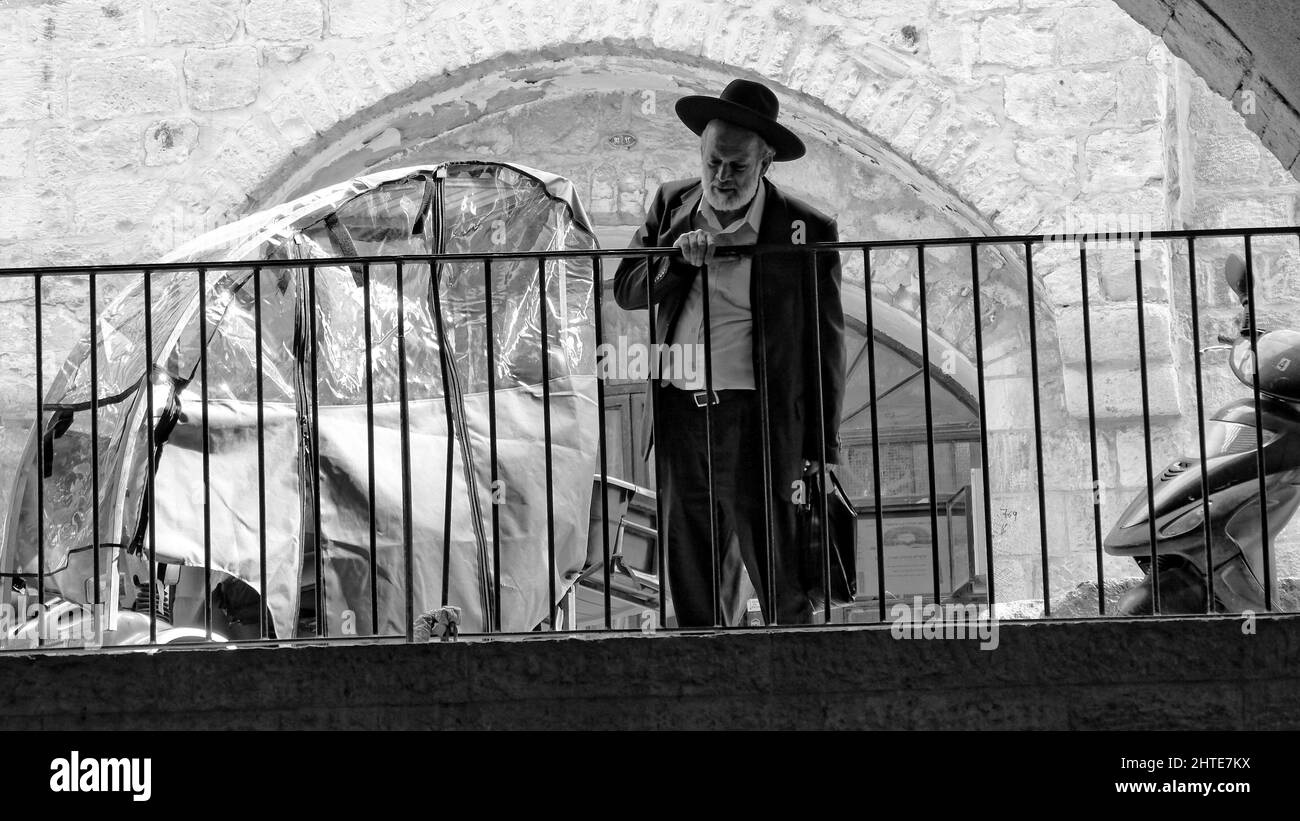 Grayscale of an old man looking down over the balcony Stock Photo - Alamy