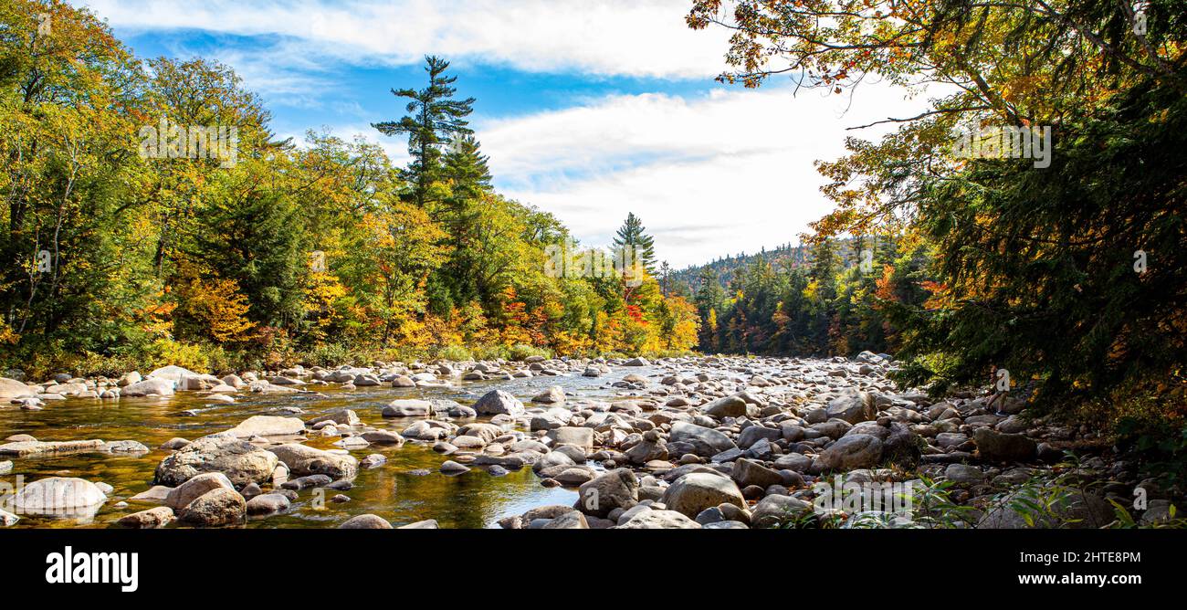 Scenic panoramic view of a still creek surrounded by large stones and ...